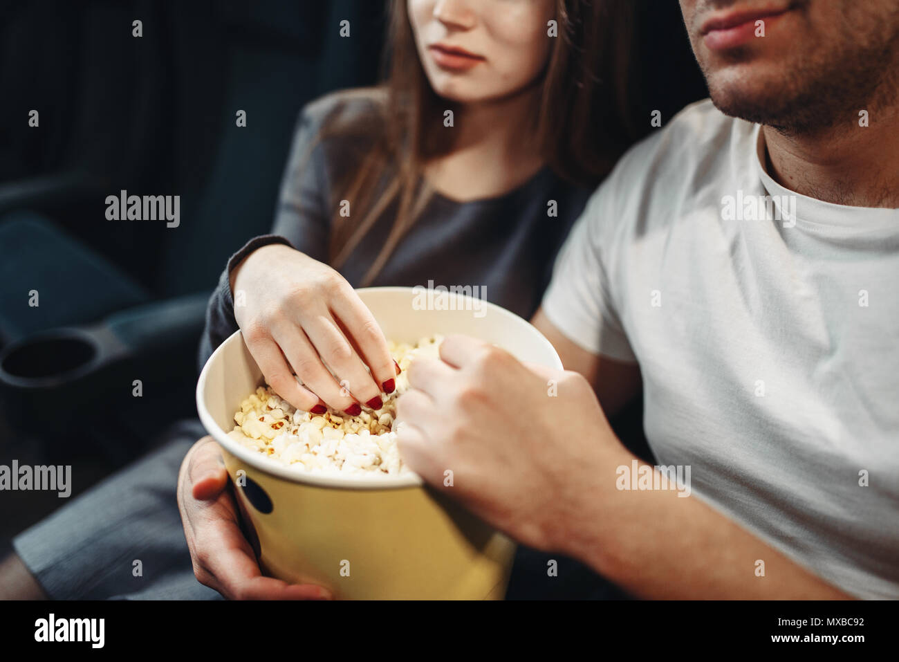 Love couple with popcorn watching movie in cinema. Showtime ...