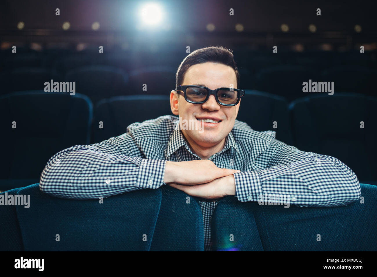 Young smiling man in 3d glasses watching the film in cinema. Showtime ...