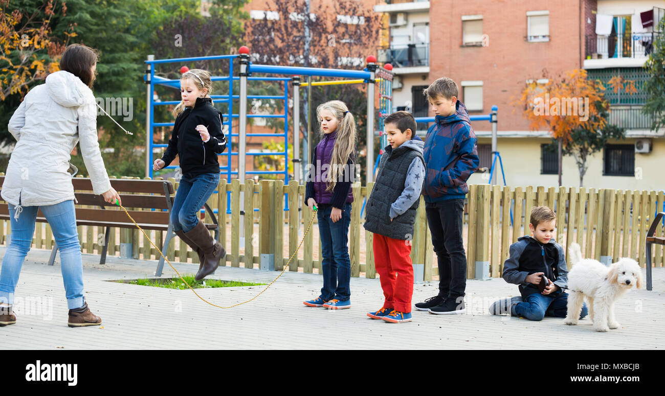 positive american children playing rubber band jumping game and ...