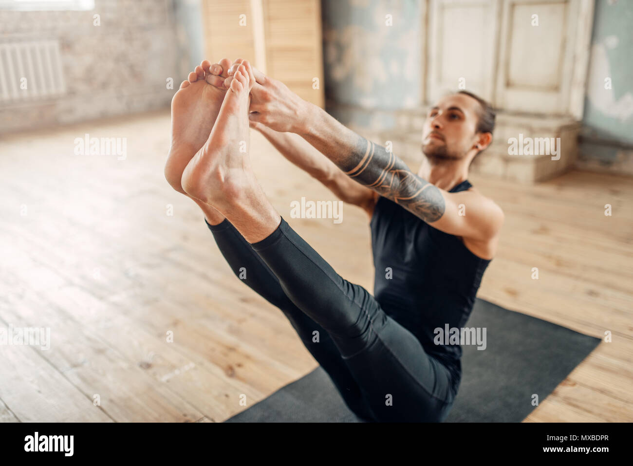 Male yoga in class, press training. Exercise on mat in gym with grunge ...