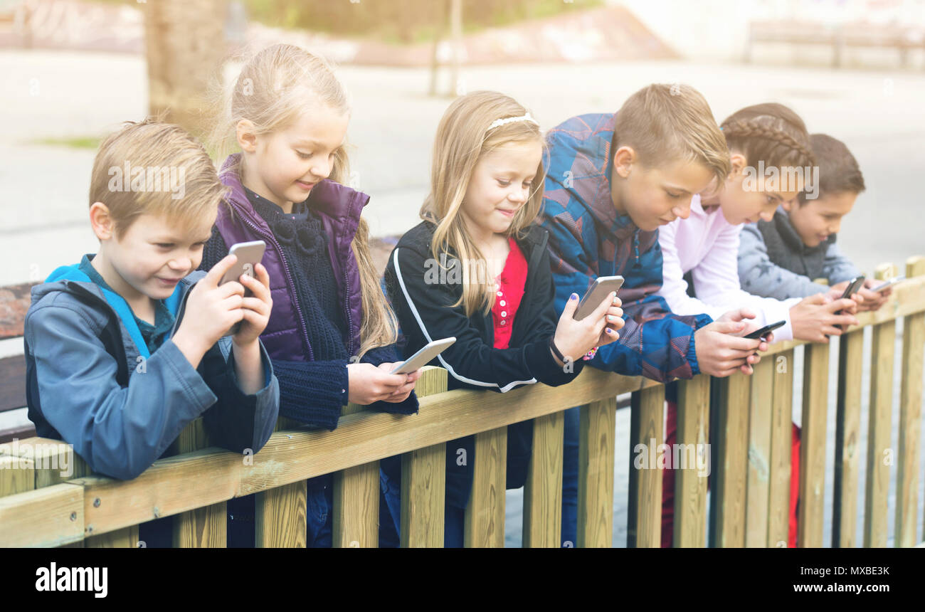 Preschool children sitting with smartphones outdoor Stock Photo - Alamy