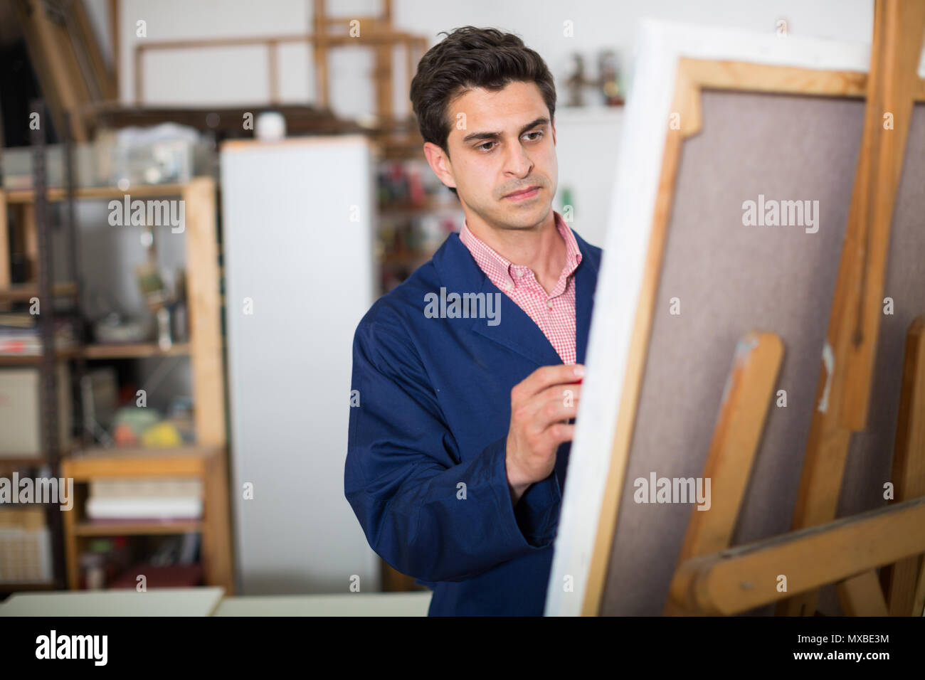 Happy art painter holding artist palette and painting on canvas Stock ...