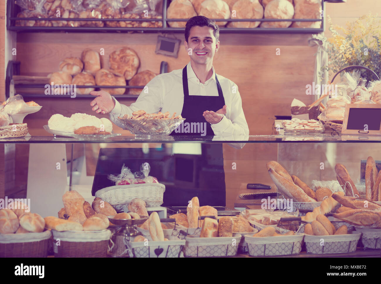 Portrait of friendly man at bakery display with pastry Stock Photo - Alamy