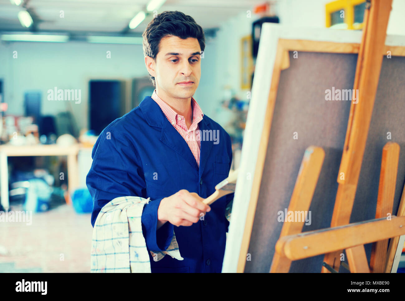 Happy art painter holding artist palette and painting on canvas Stock ...