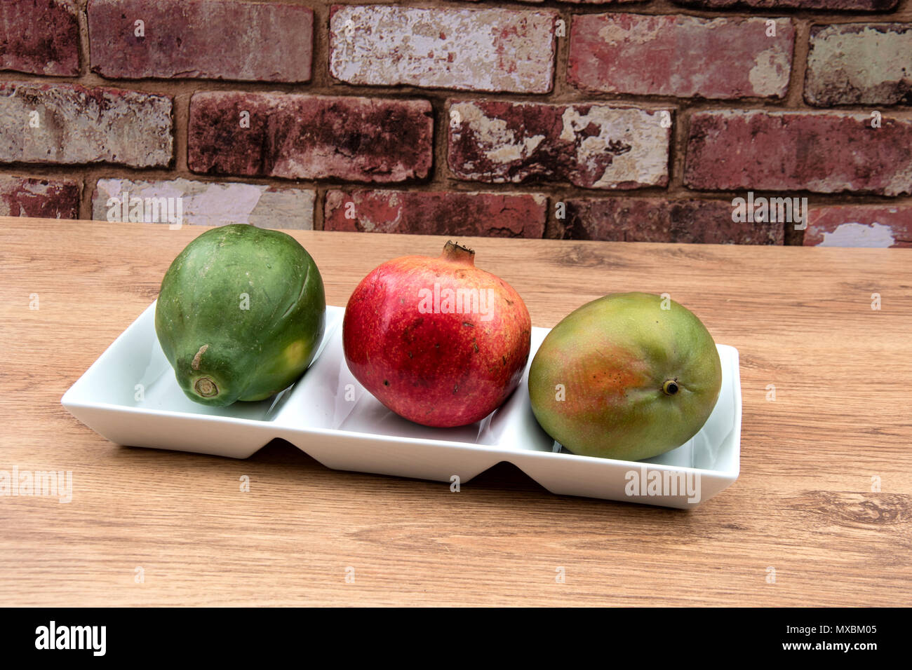 Still Life. Three tropical fruits in a white dish Stock Photo - Alamy