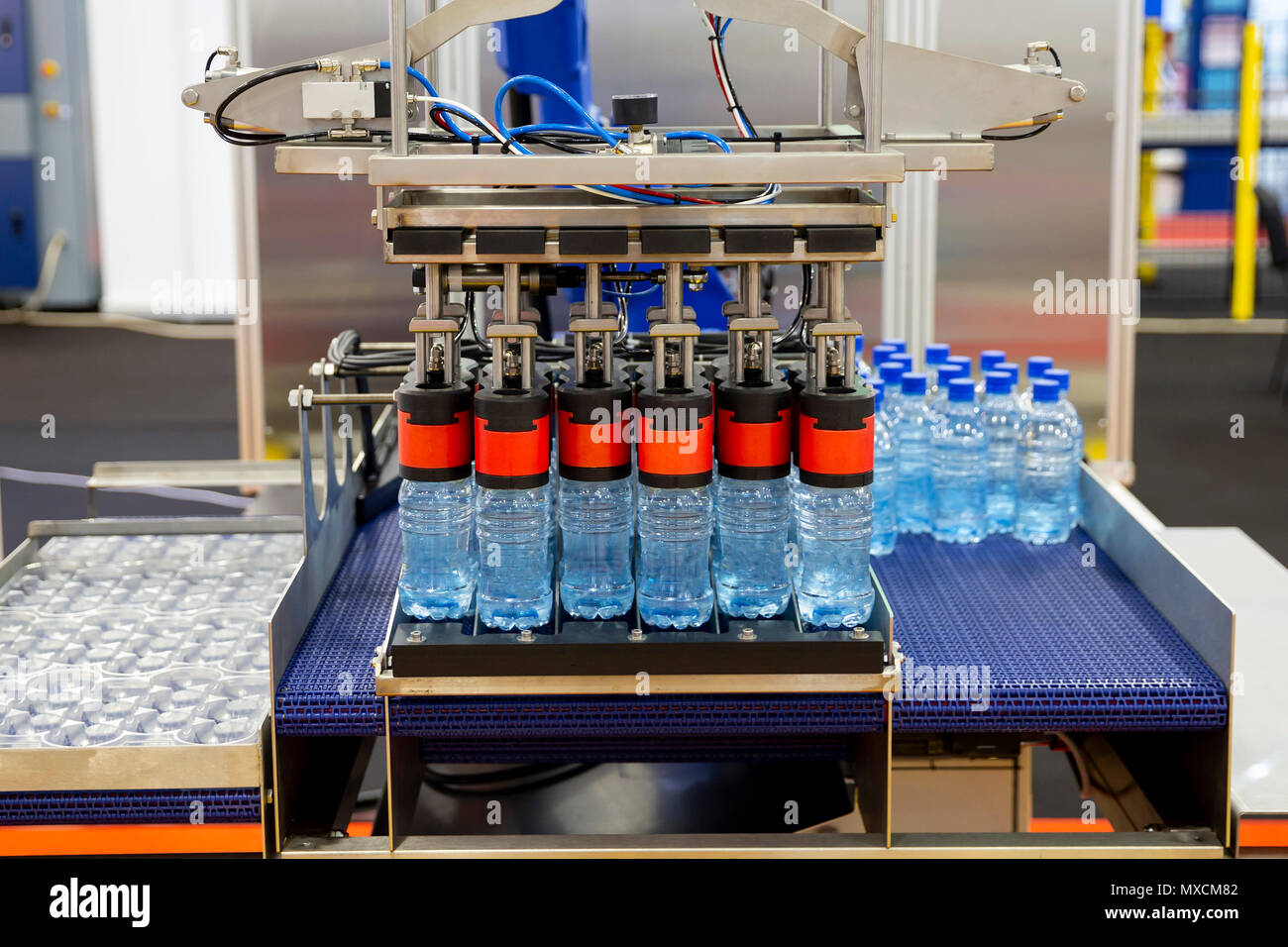 Robotic arm arranges plastic water bottles in ? packing case. Automatic ...