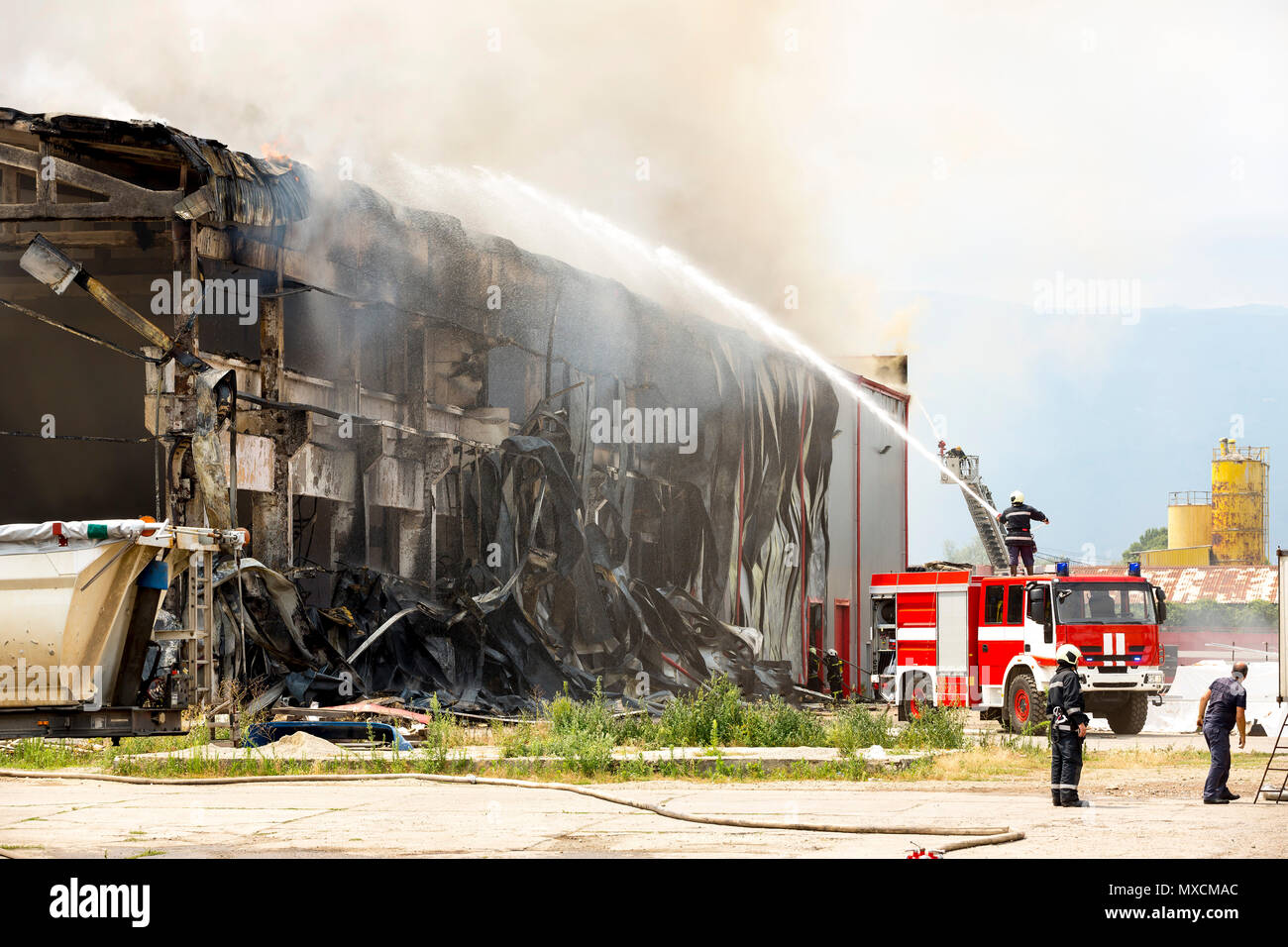 Fire disaster in a warehouse. Fire fighting in an industrial area. Red ...