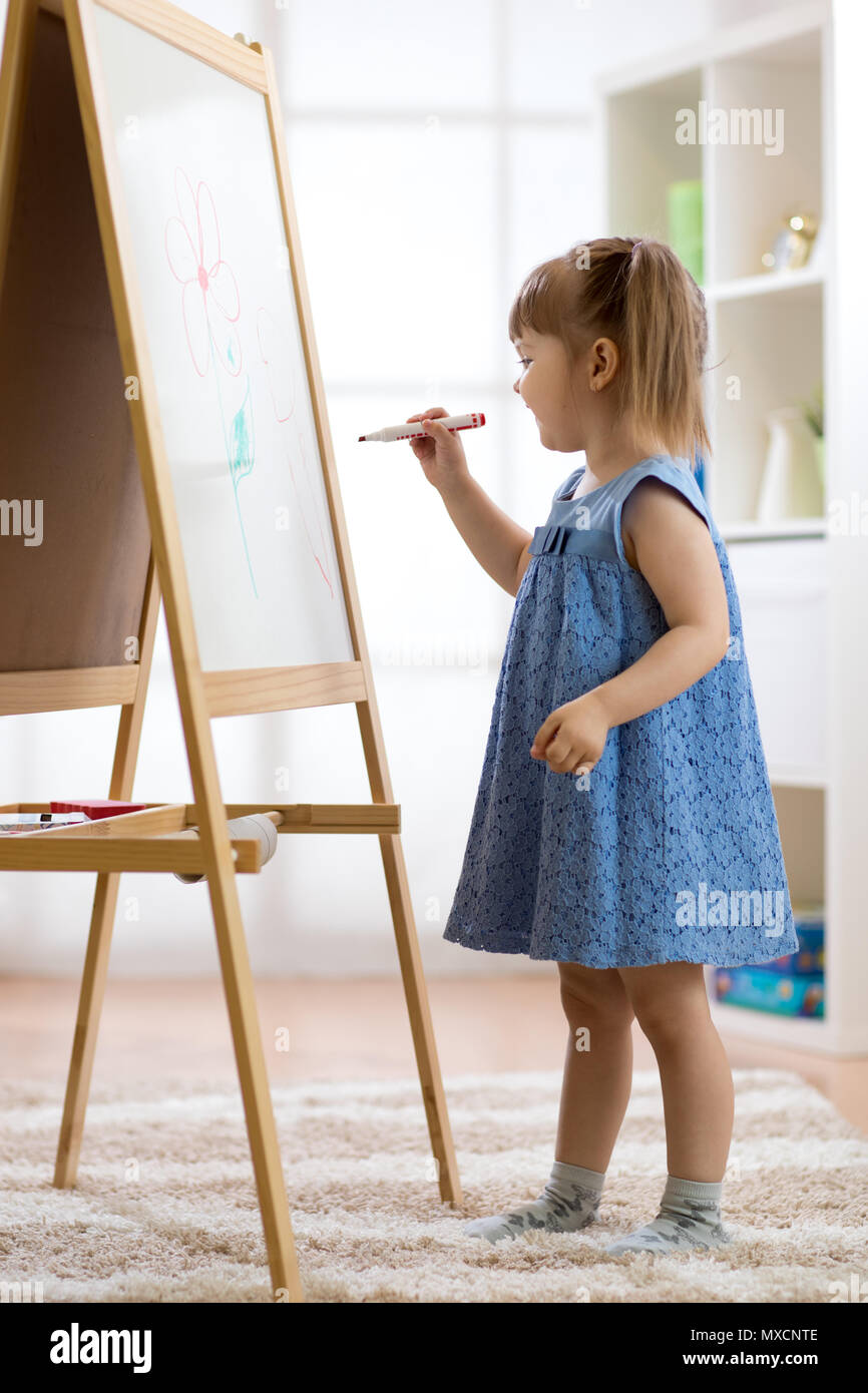 Kid girl drawing on white board Stock Photo - Alamy