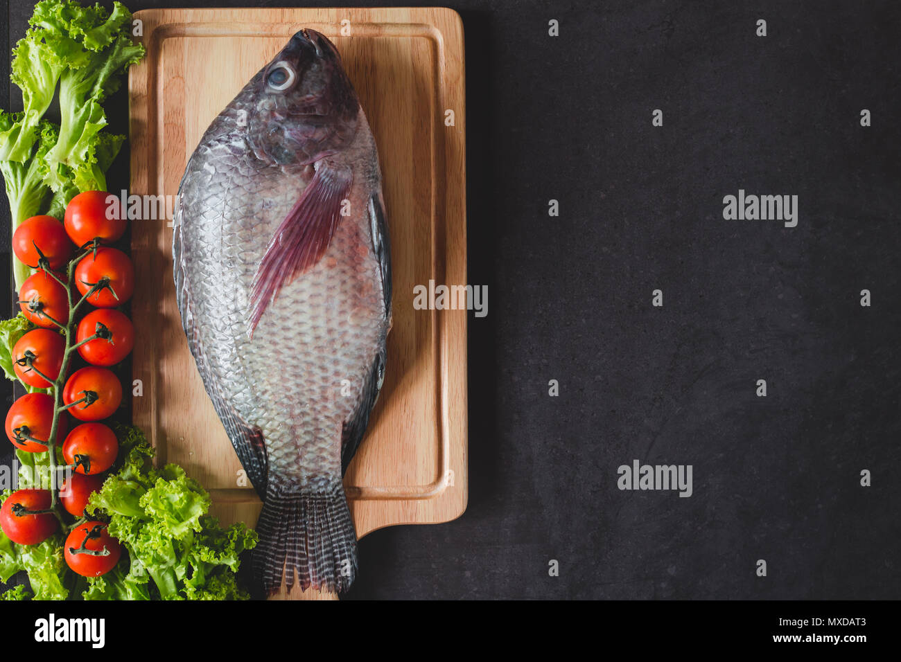 Raw fish cooking and ingredients. herbs and spices. Top view on stone ...