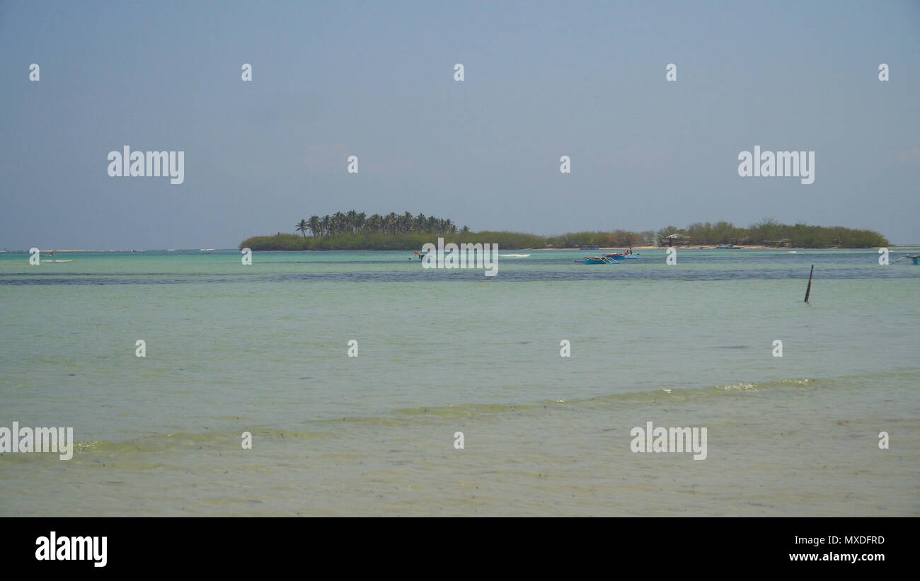 Tropical island with white sandy beach, palm trees in blue lagoon ...