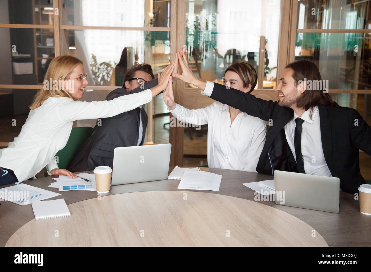 Excited work team giving high five celebrating shared achievemen Stock ...