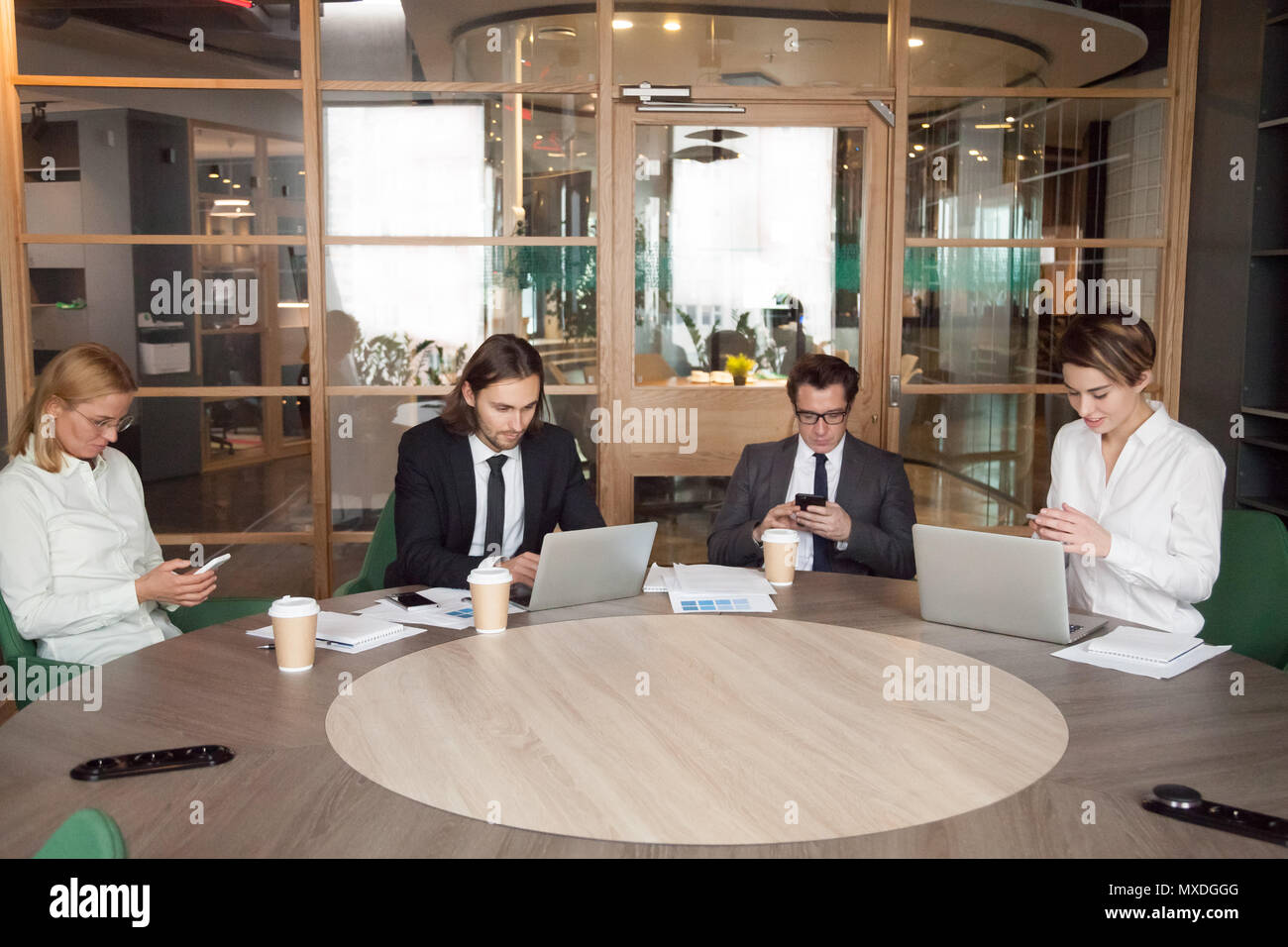 Businesspeople using devices during company business meeting Stock ...