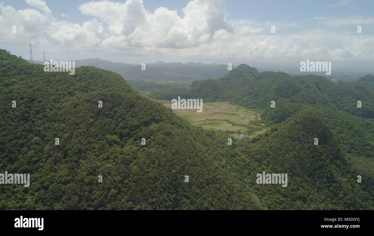 Aerial view of mountains covered rain forest, trees with clouds and sky ...