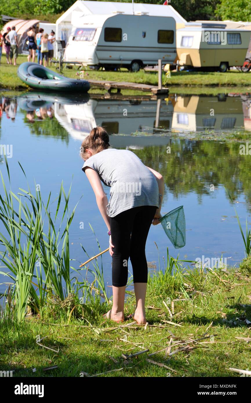 young girl on the hunt for frogs at a lake Stock Photo - Alamy
