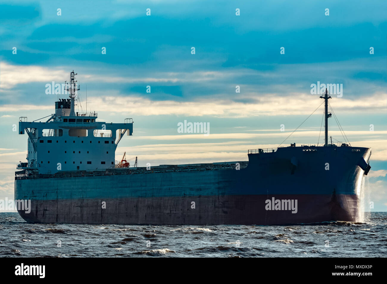 Merchandise import. Large blue cargo ship moving to Riga port Stock ...