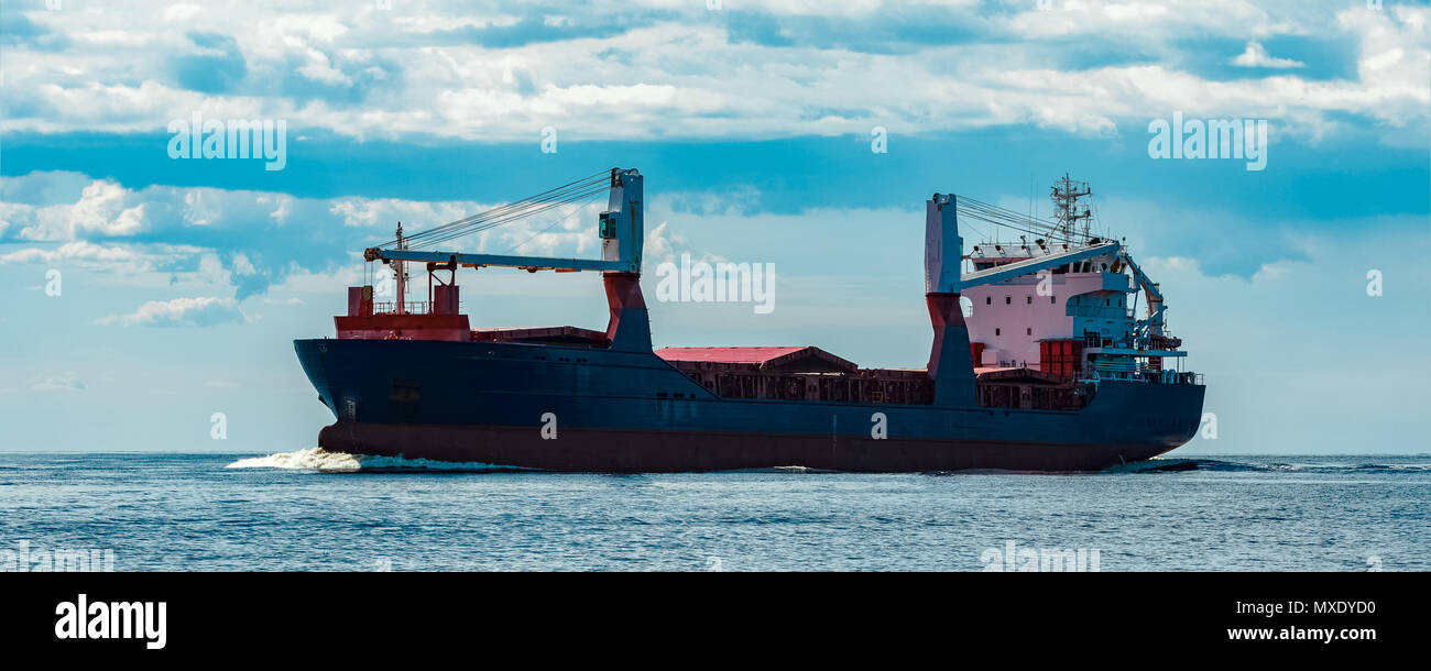 Merchandise import. Large blue cargo ship moving to Riga port Stock ...