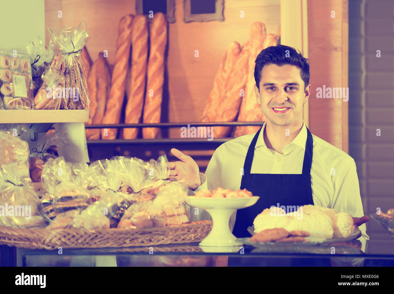 Portrait of smiling male baker at bakery display with pastry Stock ...