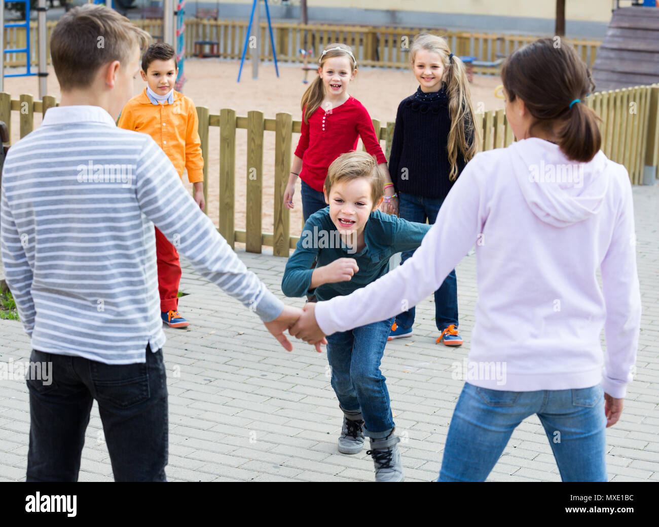 Group of smiling children playing red rover outdoors Stock Photo - Alamy