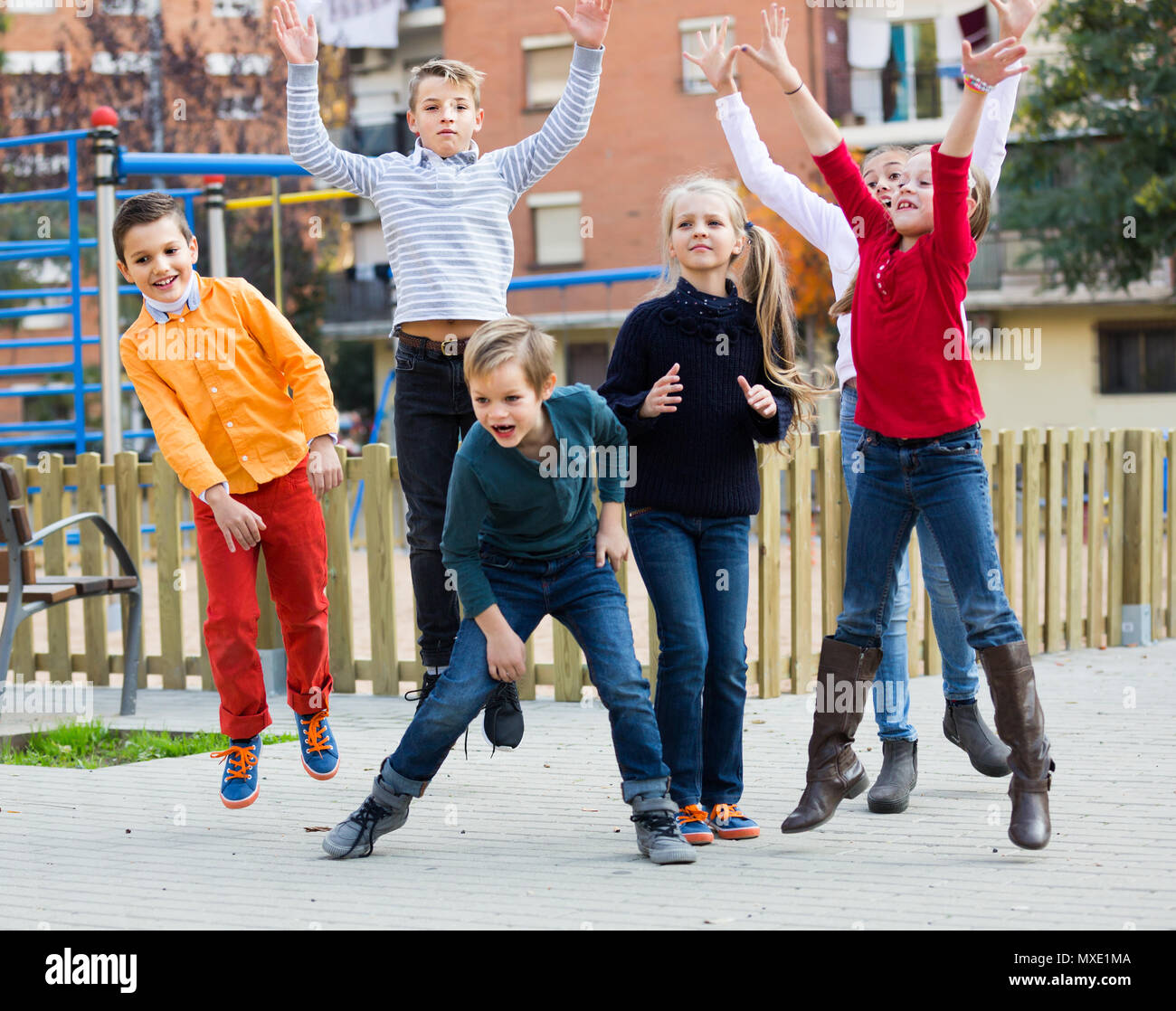 Group of cheerful kids in high spirits jumping outdoors Stock Photo - Alamy