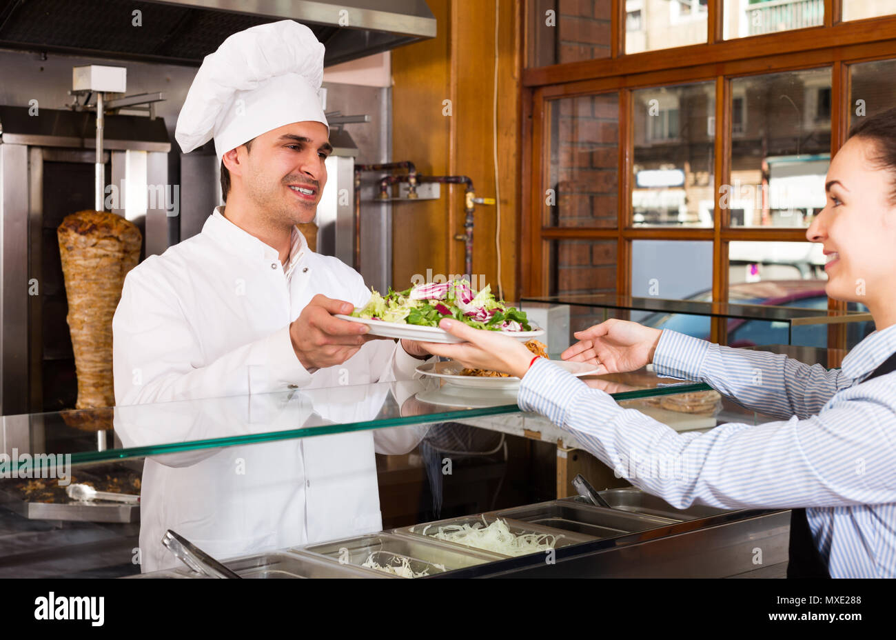 Ordinary waitress receiving order from chef at fastfood place Stock ...