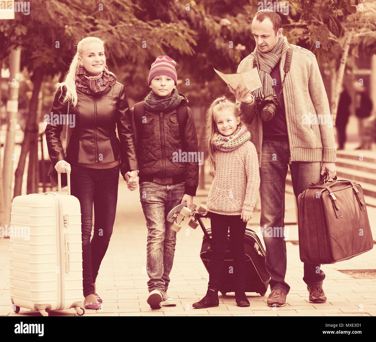 Happy middle class family of four checking a direction in a city map ...