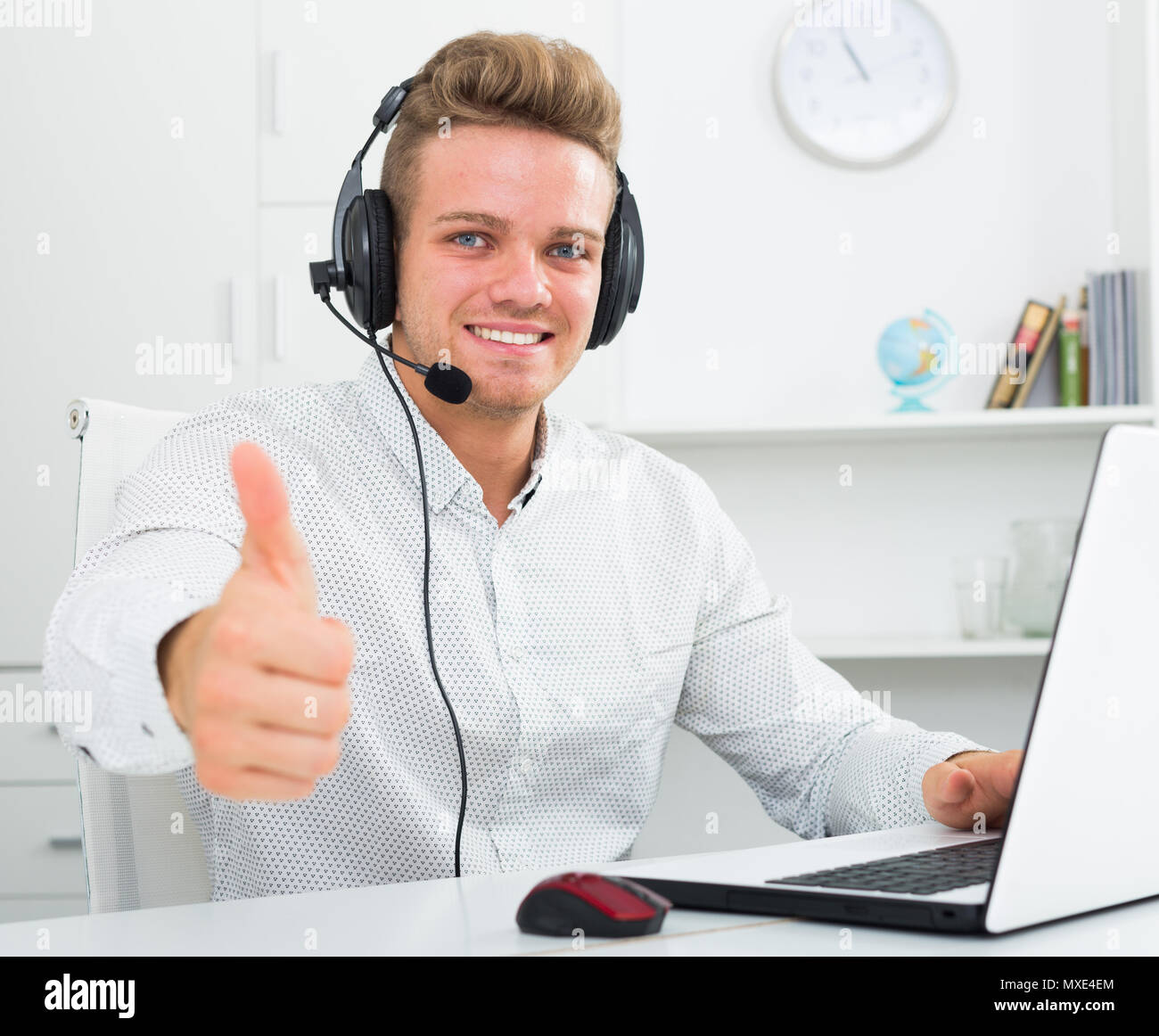 Happy man with headset and laptop showing thumbs up Stock Photo - Alamy