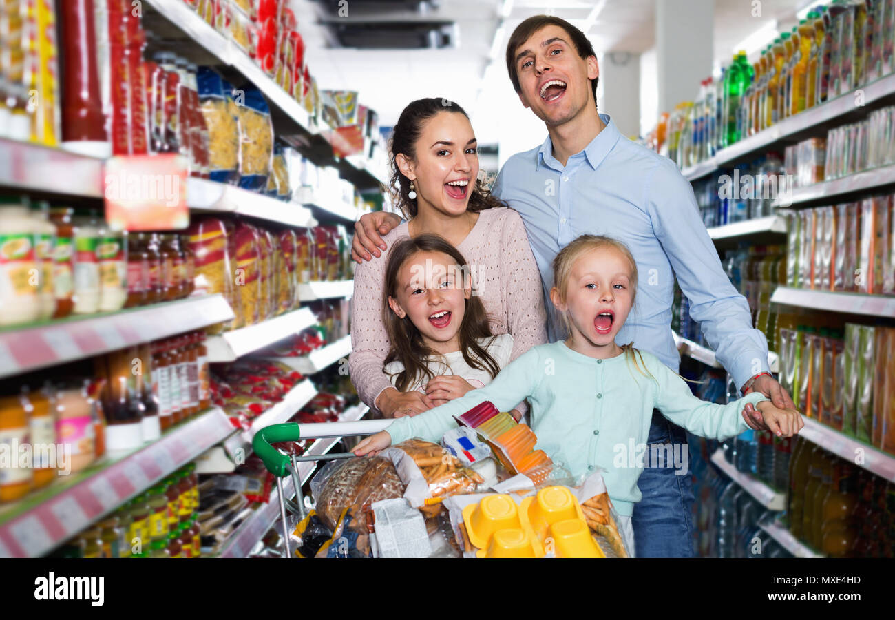 Happy charming customers with children buying food in hypermarket and ...