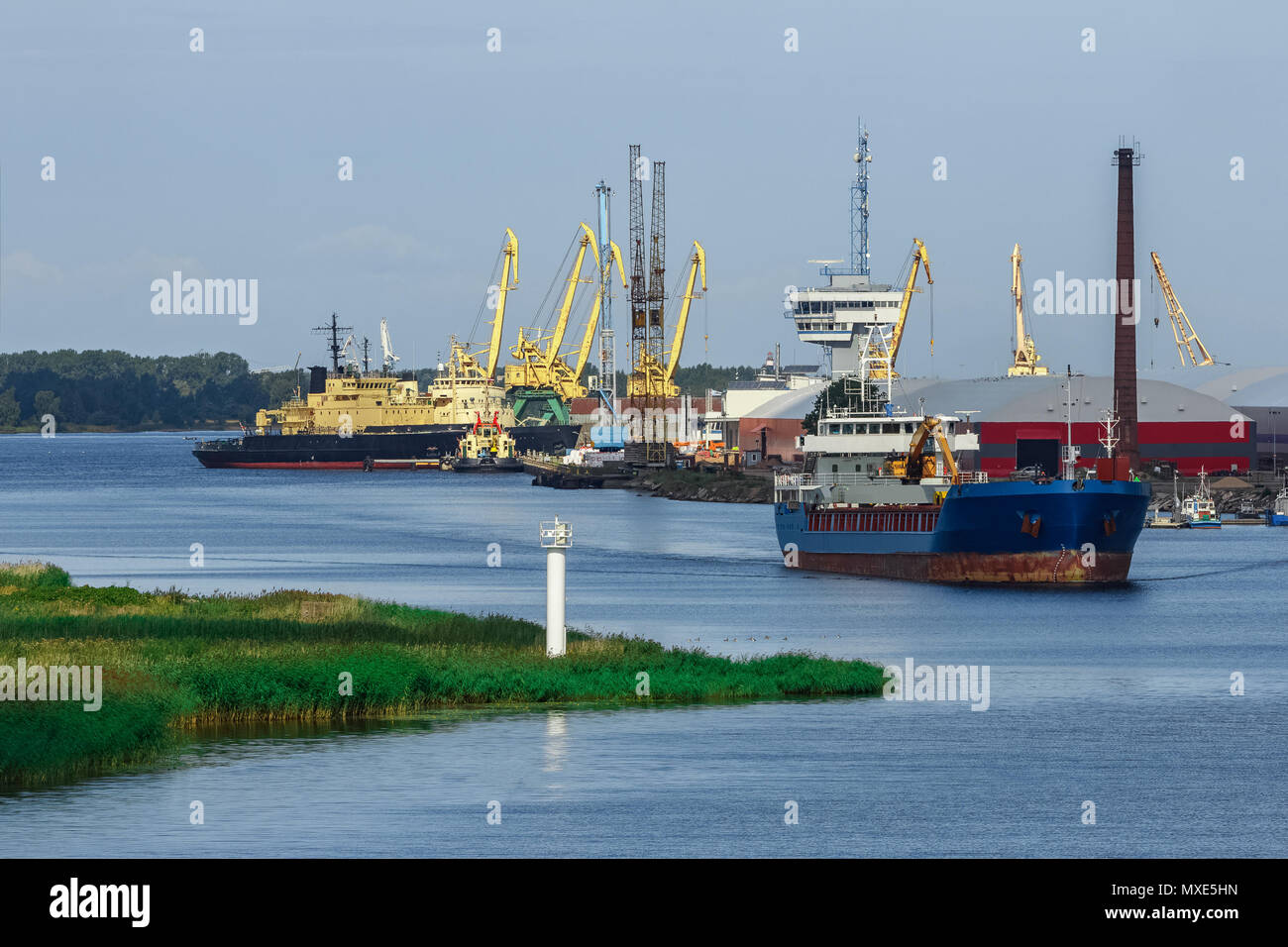 Blue cargo ship with long reach excavator moving to the port Stock ...