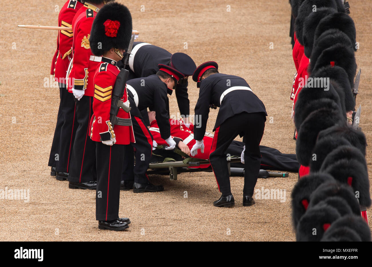 A soldier, overcome with heat, collapses and is stretchered off the ...