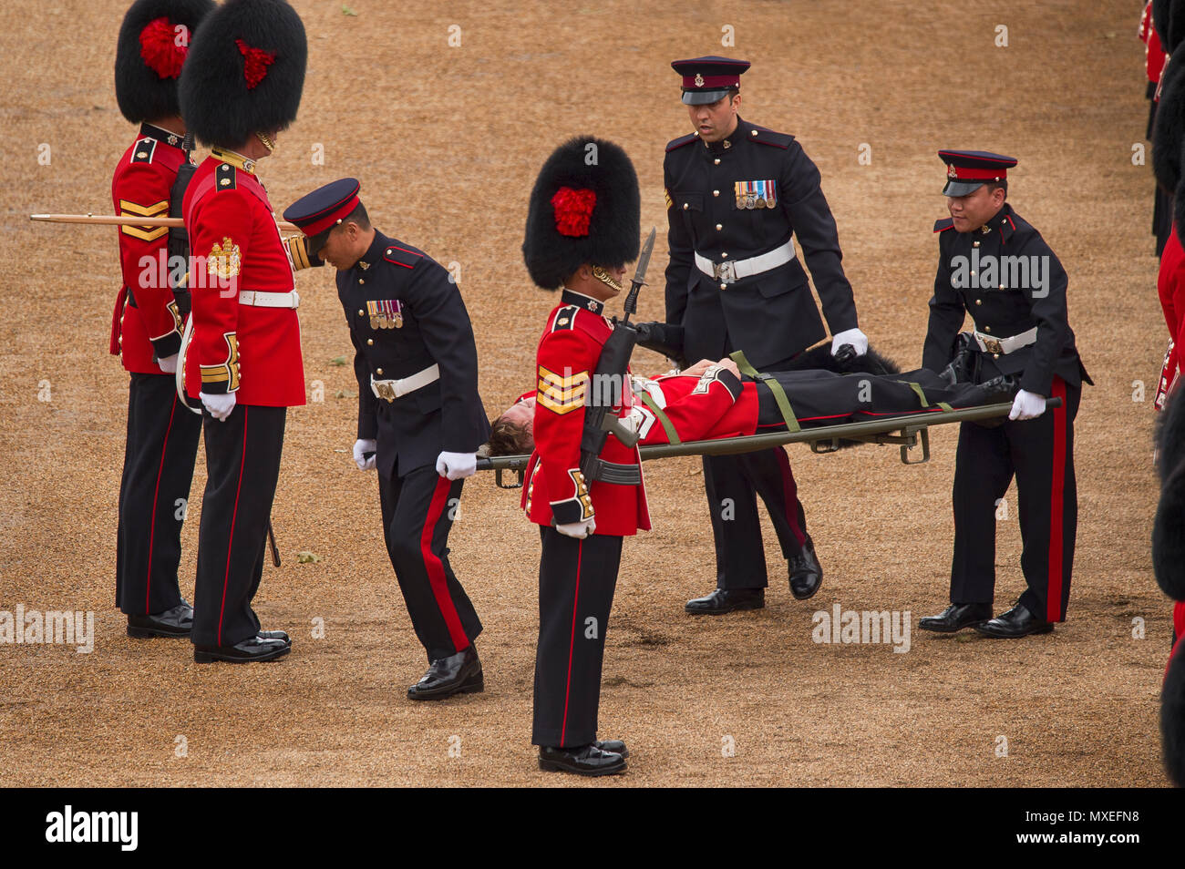 A soldier, overcome with heat, collapses and is stretchered off the ...