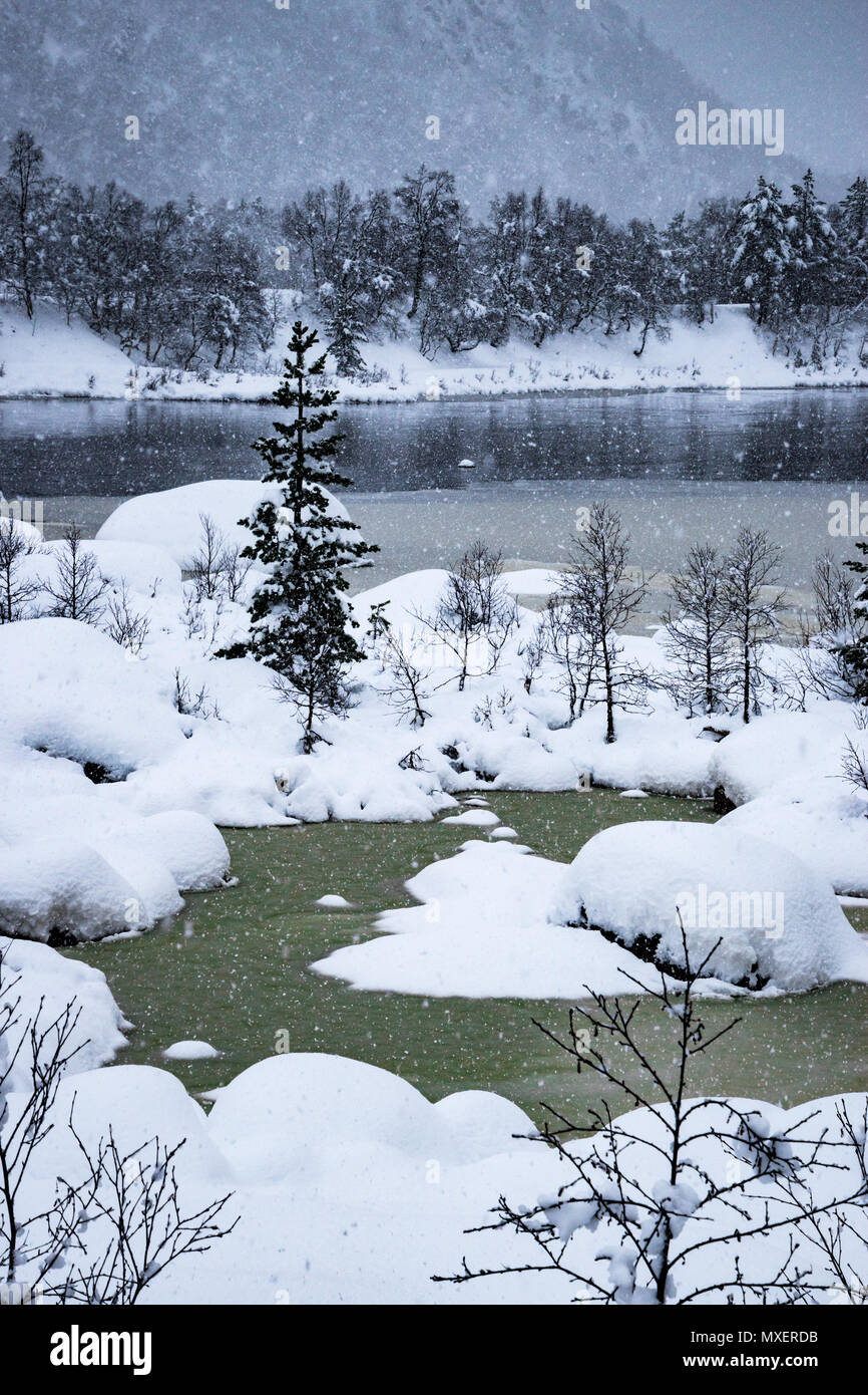Lake half frozen in winter snowing Stock Photo - Alamy