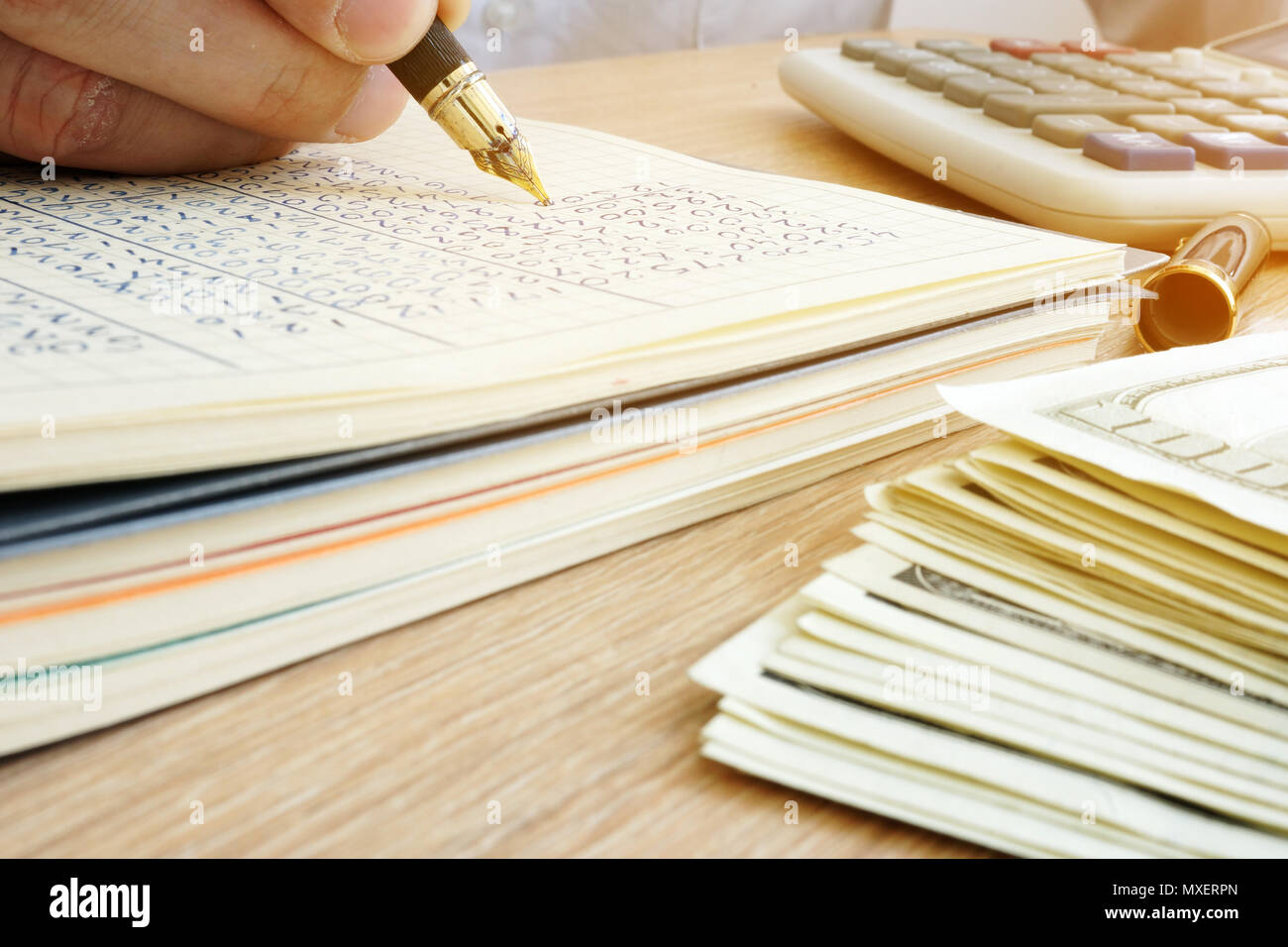 Bookkeeper writing business report. Documents, money and calculator ...