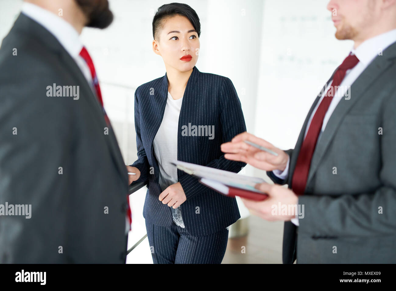 Discussing Joint Project at Office Lobby Stock Photo - Alamy