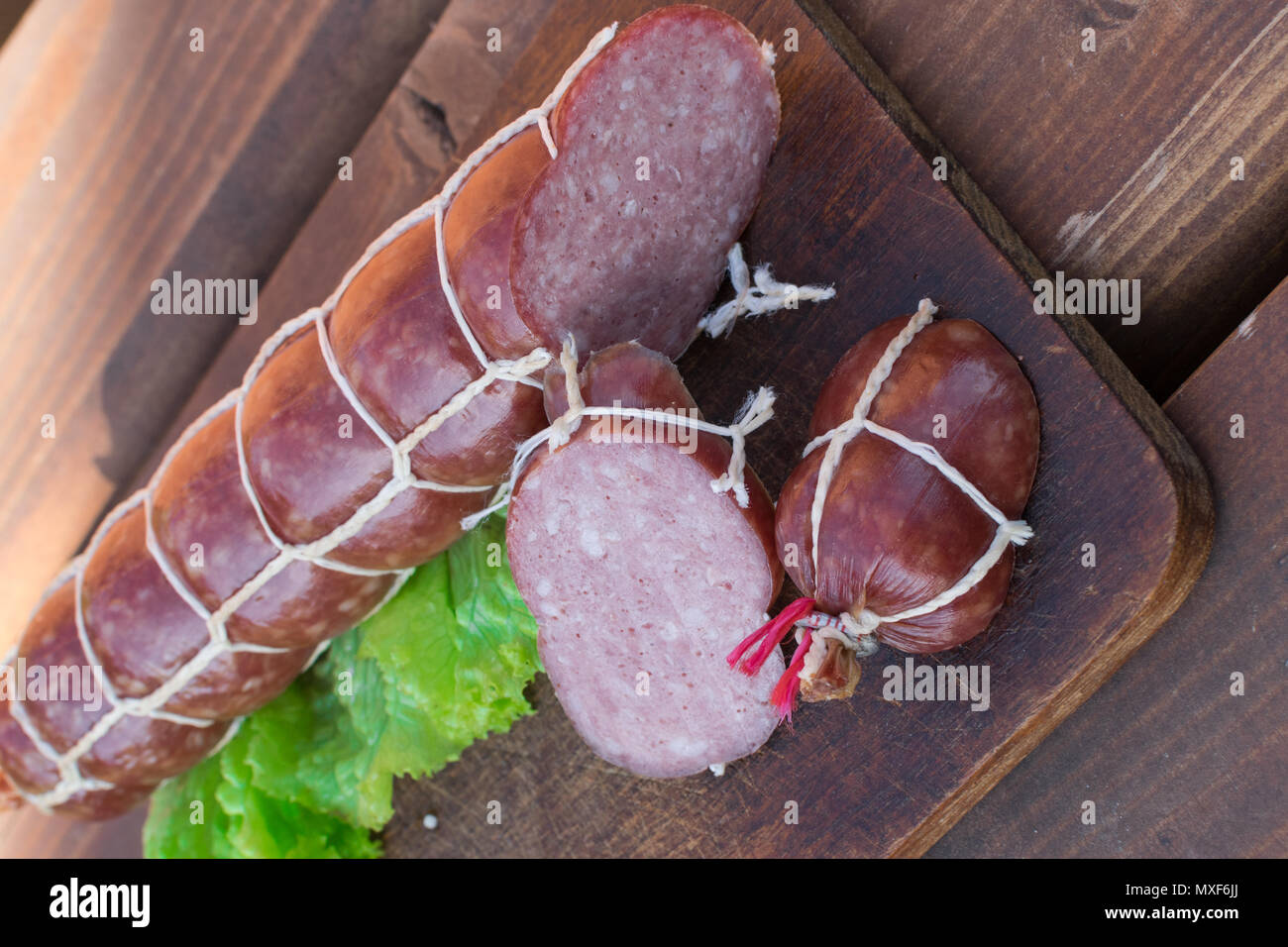 italian cutting salami on ancient wood table with green lettuce Stock ...
