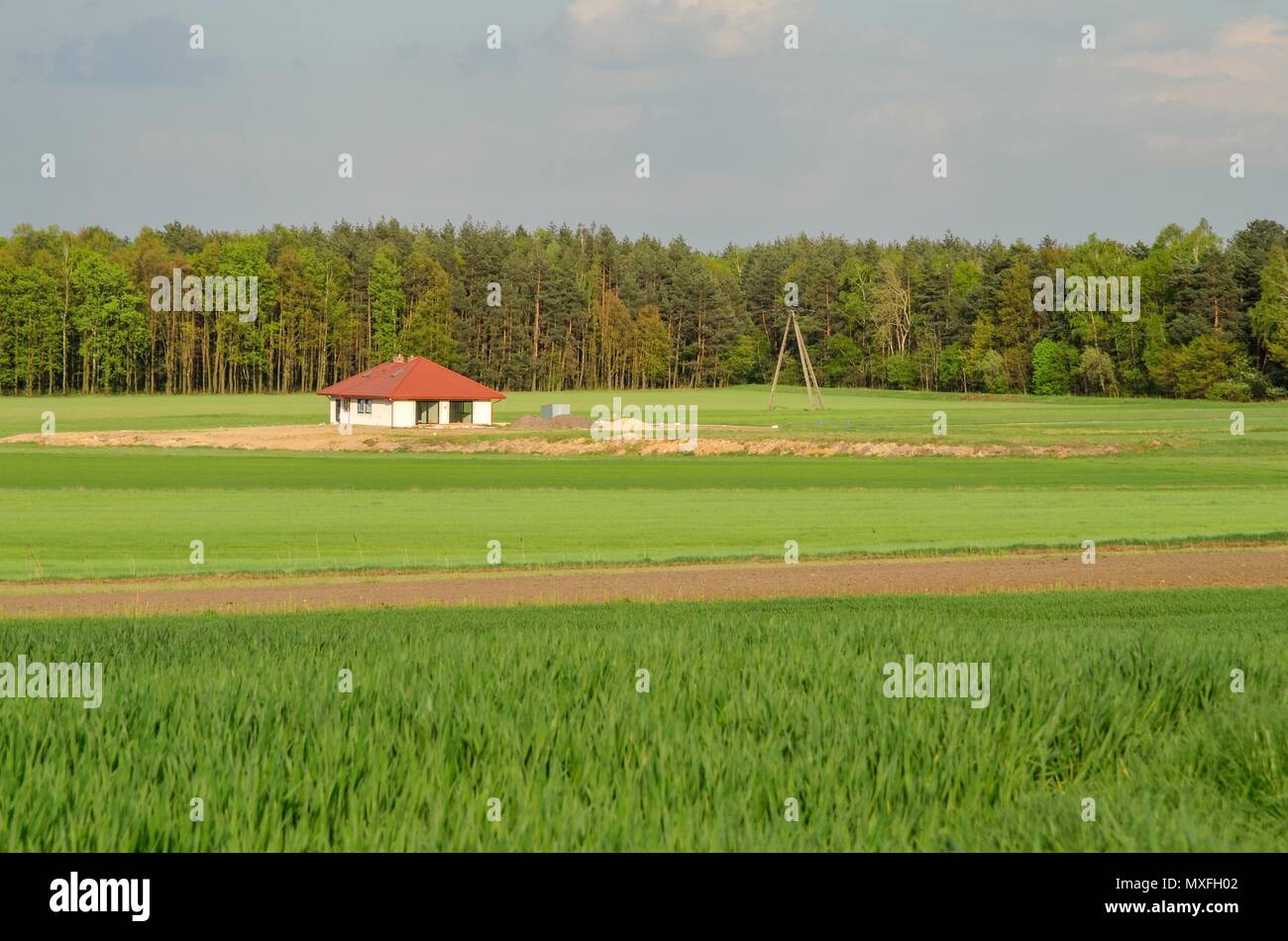 Spring rural landscape. Construction of a new home in the countryside ...