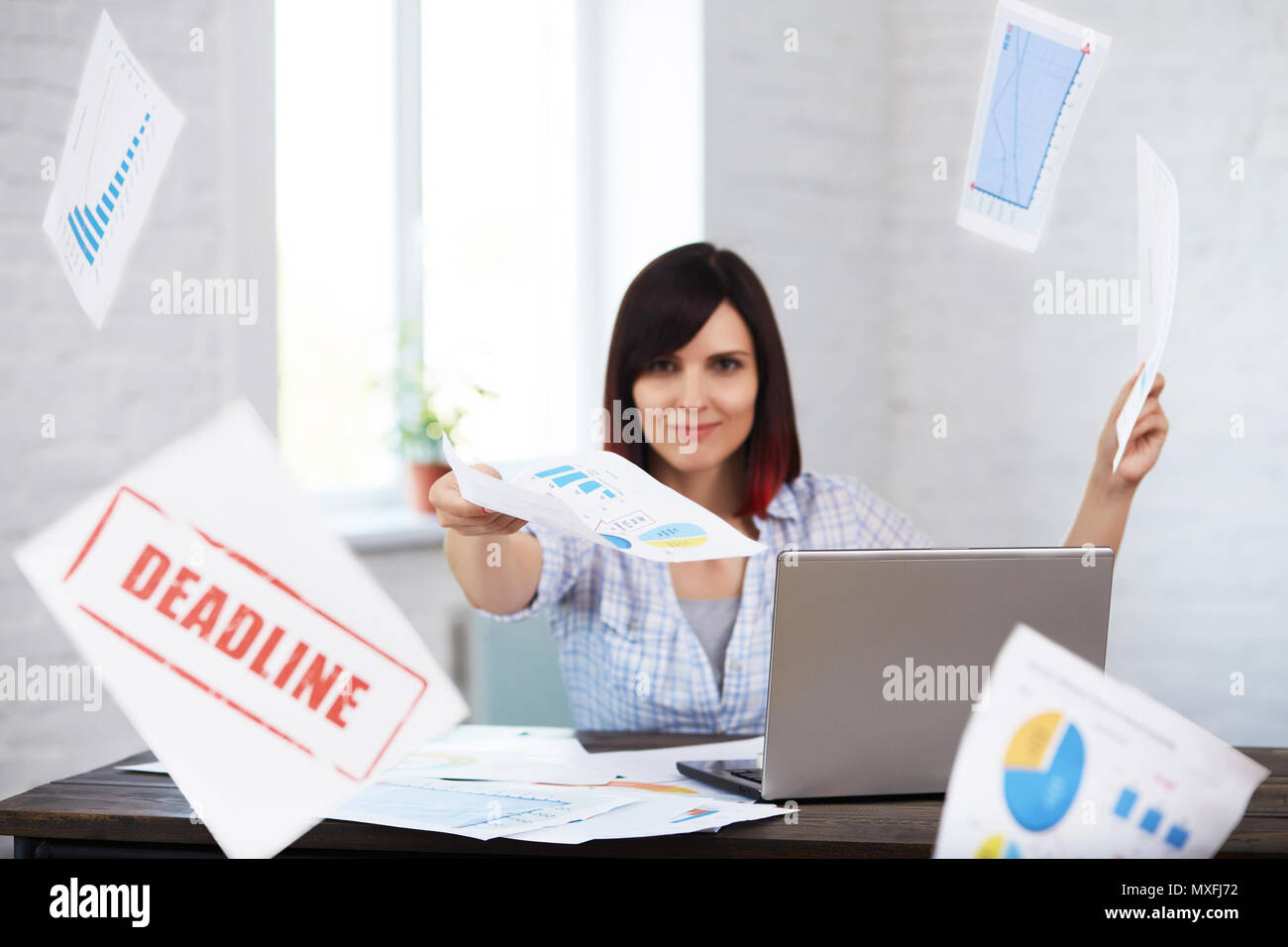 Happy and smiling female worker throws documents in office with falling ...