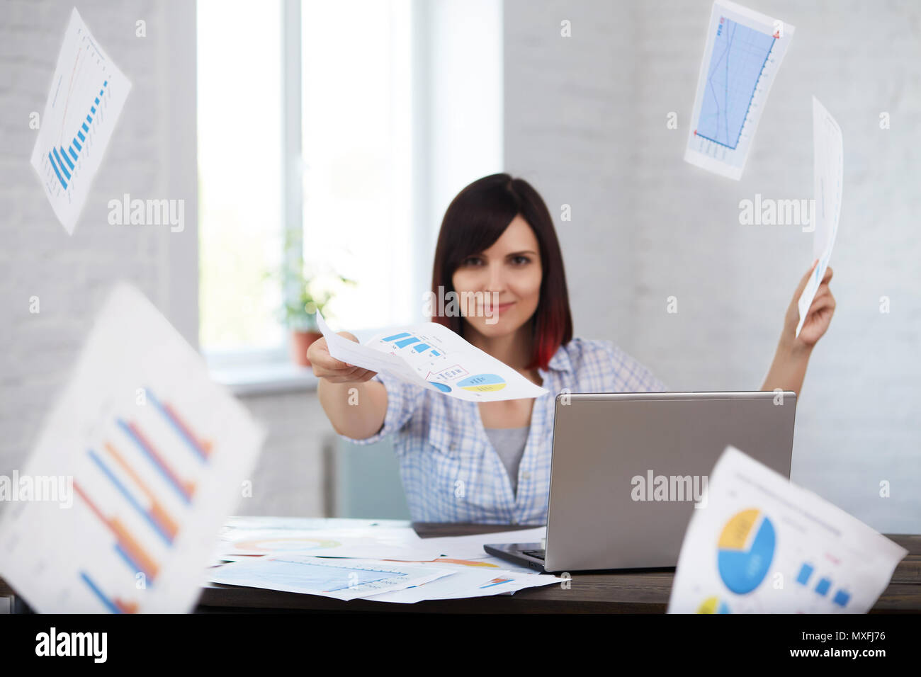 Happy and smiling female worker throws documents in office with falling ...
