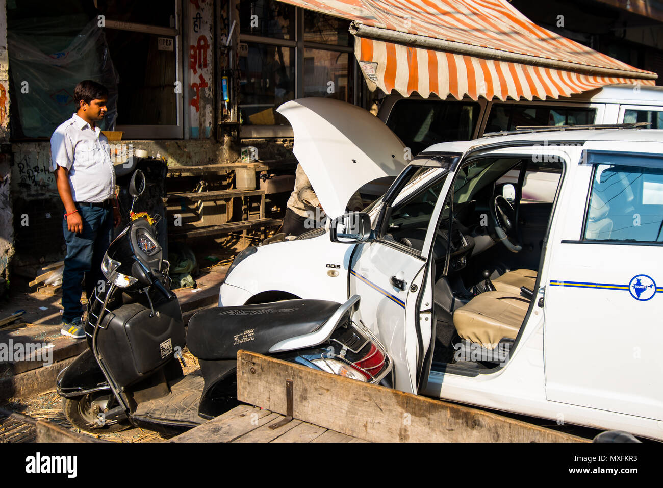 A car workshop on the street. The driver watches with regret as the ...