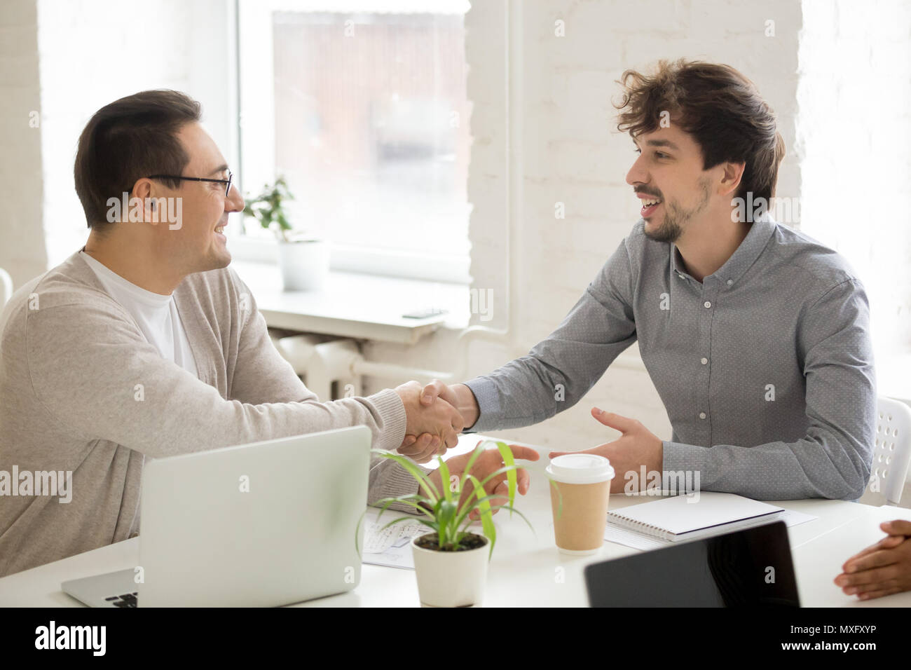 Worker congratulating business colleague with handshake at compa Stock ...