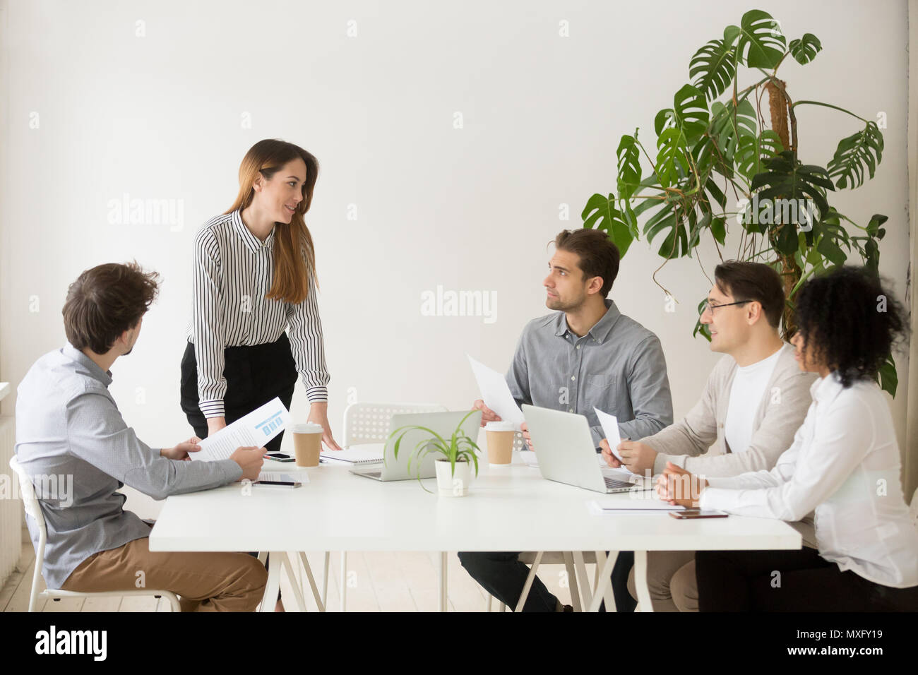 Female business coach making presentation to workers Stock Photo - Alamy