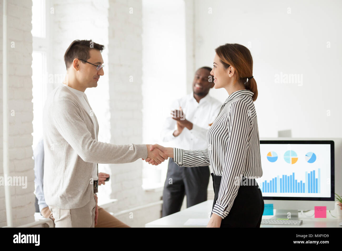Male CEO shaking hand of female worker congratulating with succe Stock ...