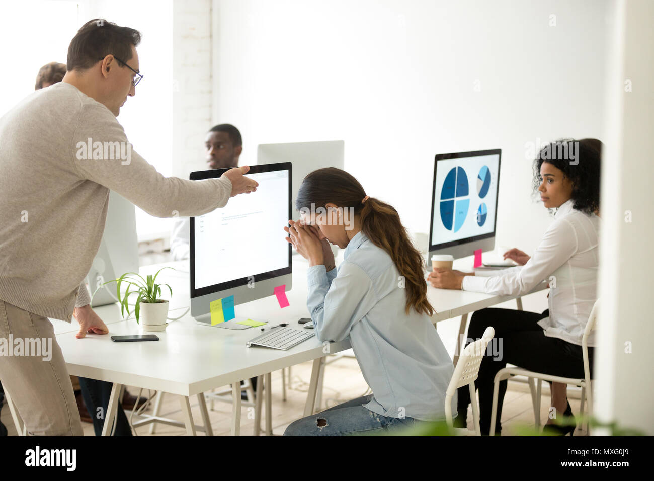 Mad middle aged boss lecturing female young employee in office Stock ... Mad middle aged boss lecturing female young employee in office Stock ...