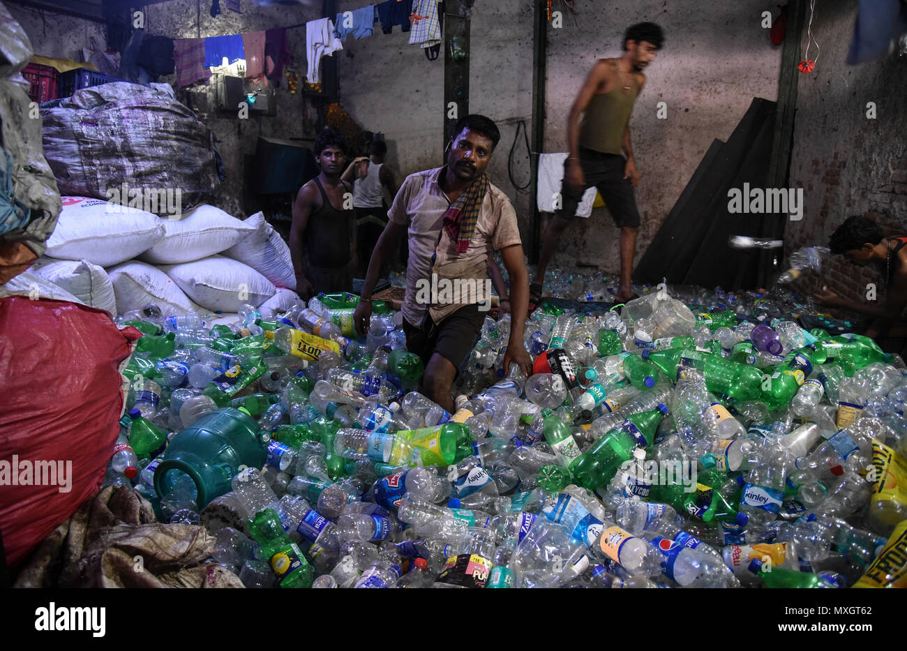 Mumbai. 4th June, 2018. Indian workers try to sort plastic bottles at a ...