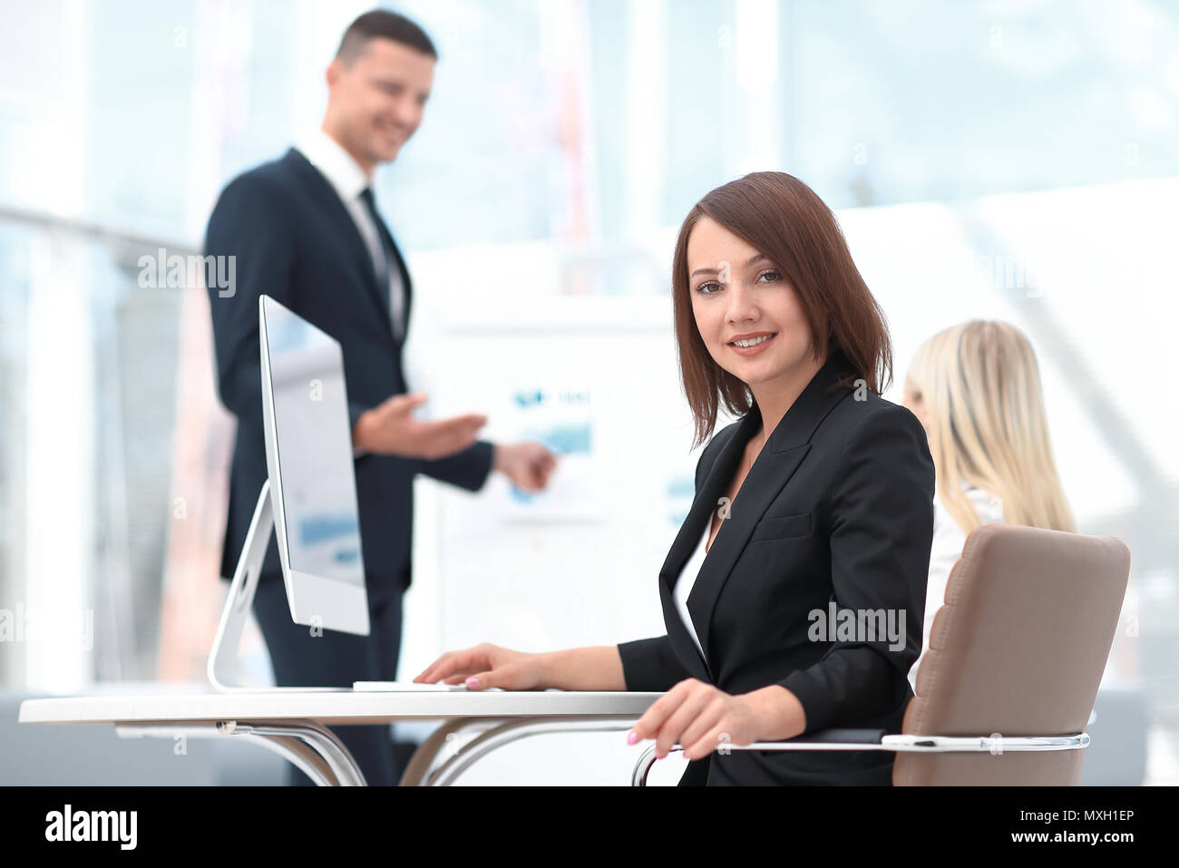 portrait of a successful female assistant sitting at a Desk Stock Photo ...