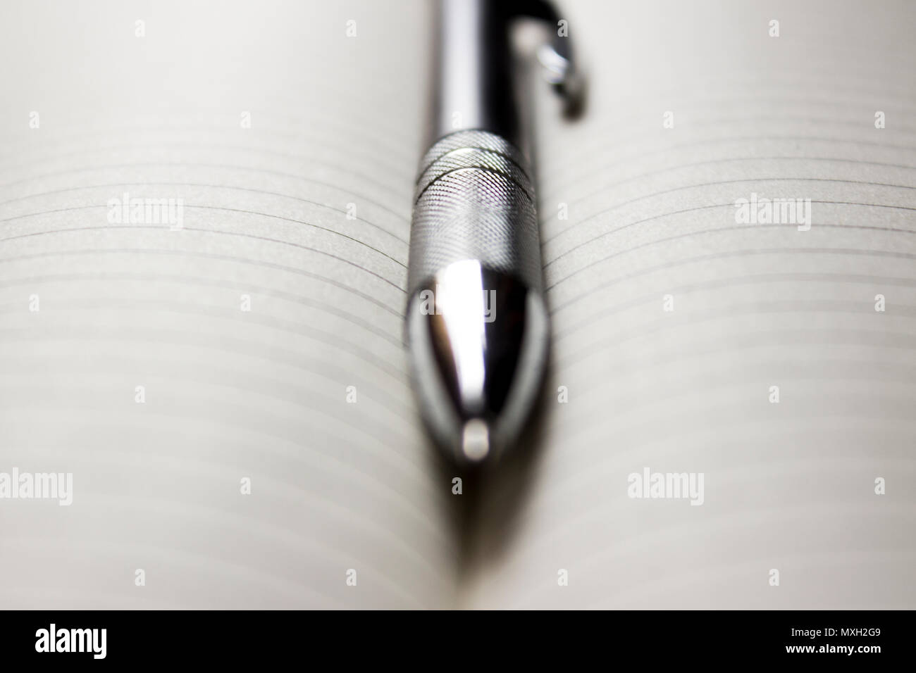 Pen laying over notebook Stock Photo - Alamy