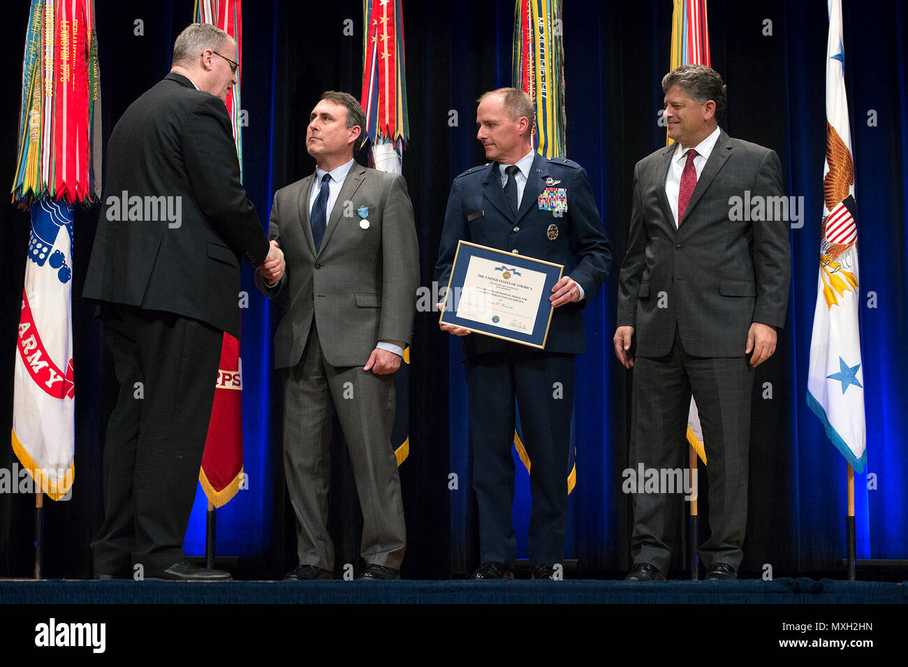 Deputy Defense Secretary Bob Work, left, congratulates Scott Roenicke ...