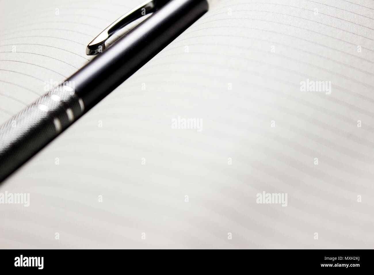 Pen laying over notebook Stock Photo - Alamy