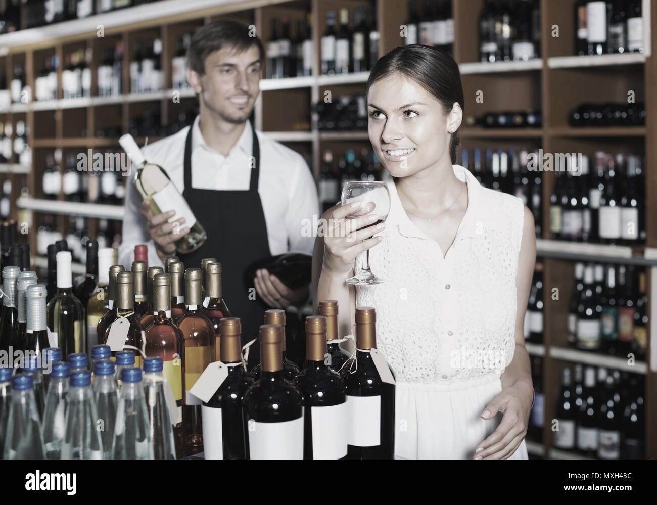 portrait of young american glad female customer tasting wine before ...