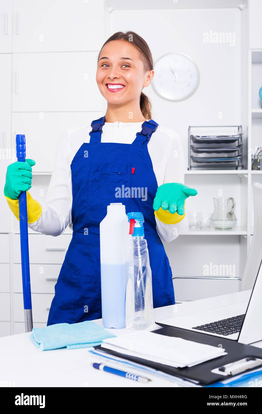 Smiling woman wearing uniform cleaning at company office Stock Photo ...