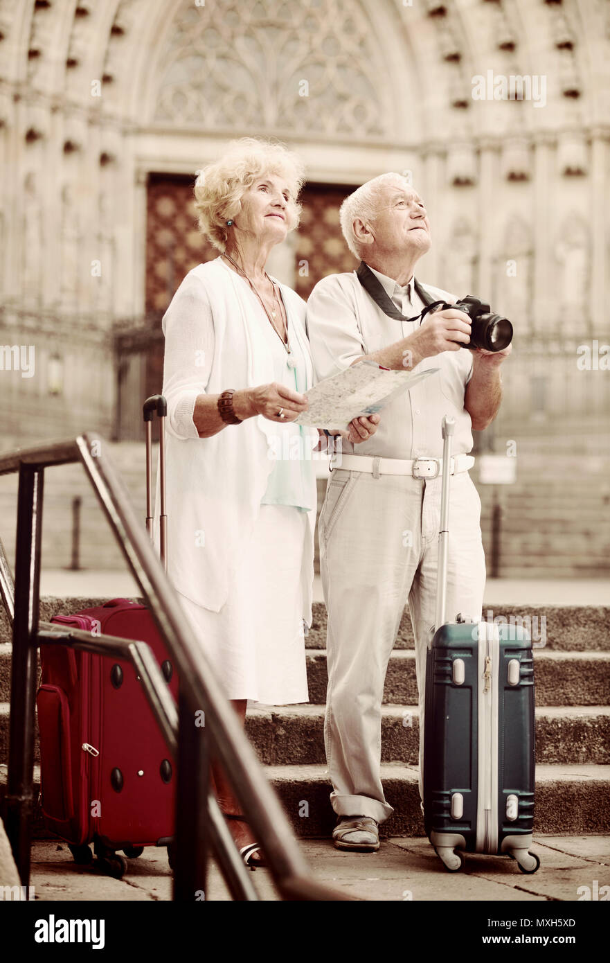 Happy cheerful smiling mature couple making photo and using map during ...